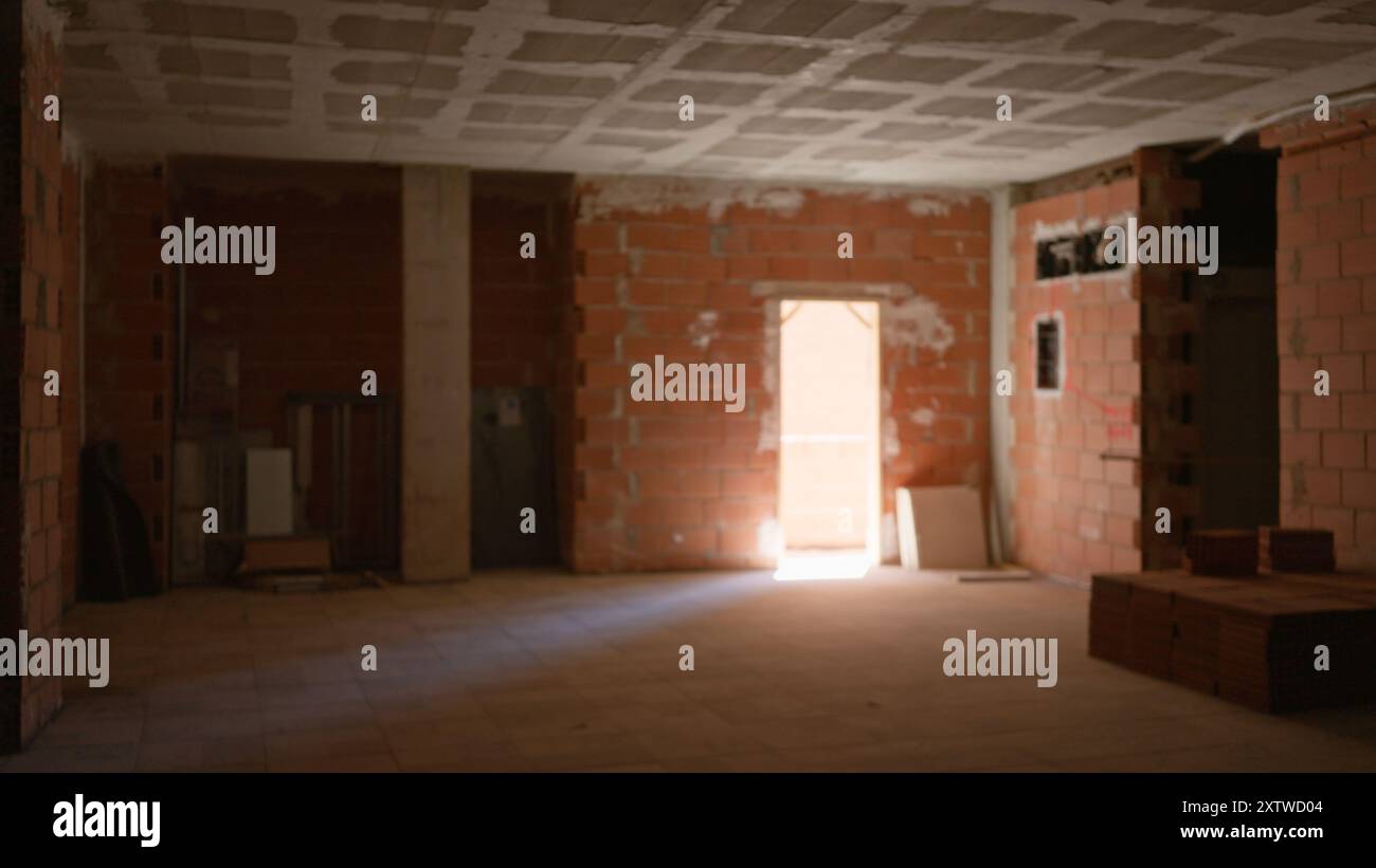 Blurred interior of an unfinished construction site with exposed brick ...