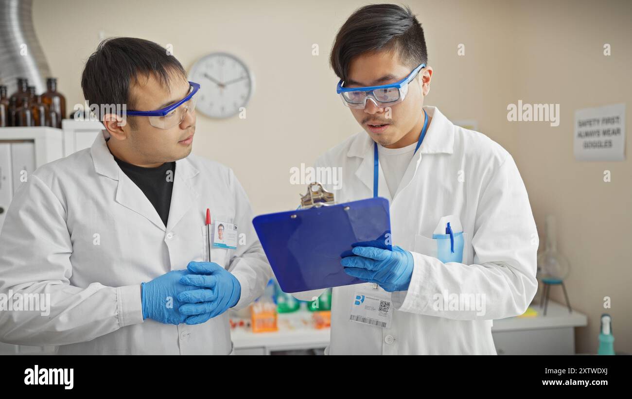 Two men working together as a team in a laboratory, examining ...