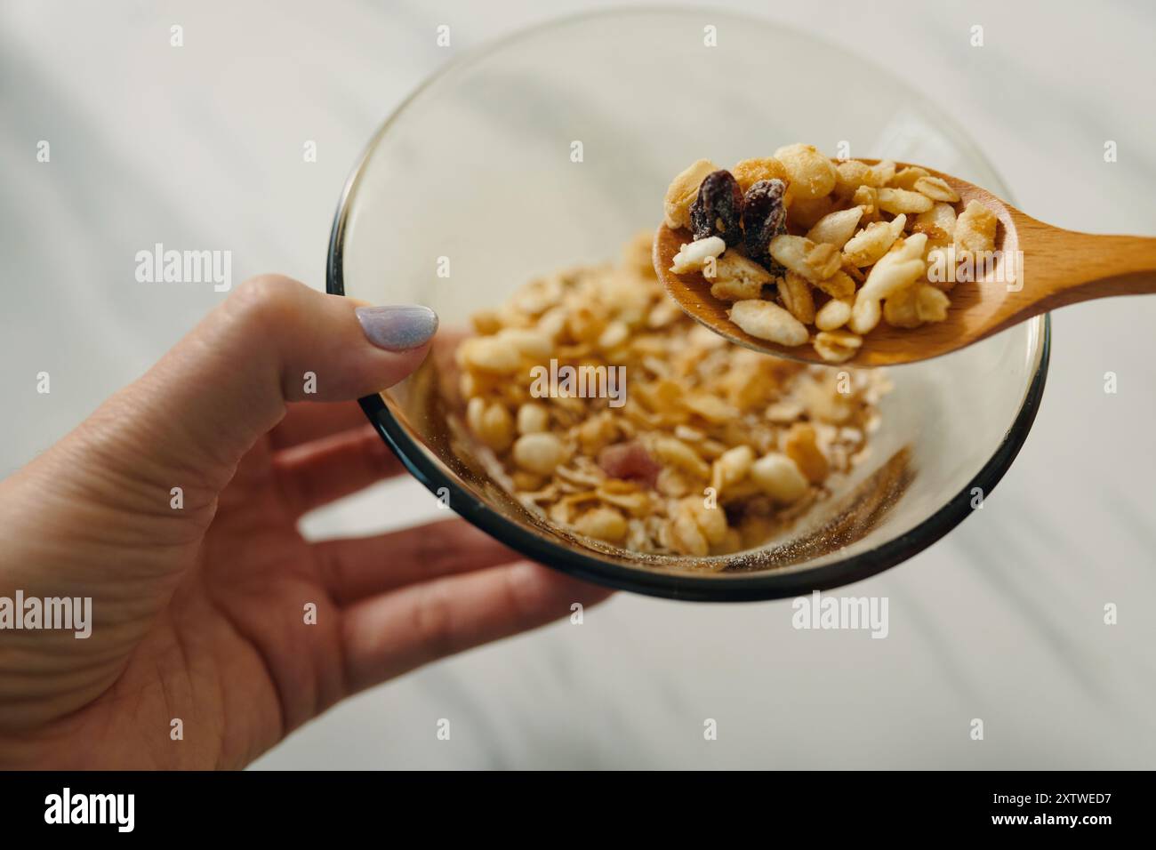 Holding Spoonful Of Mixed Nuts Above Transparent Bowl Stock Photo - Alamy