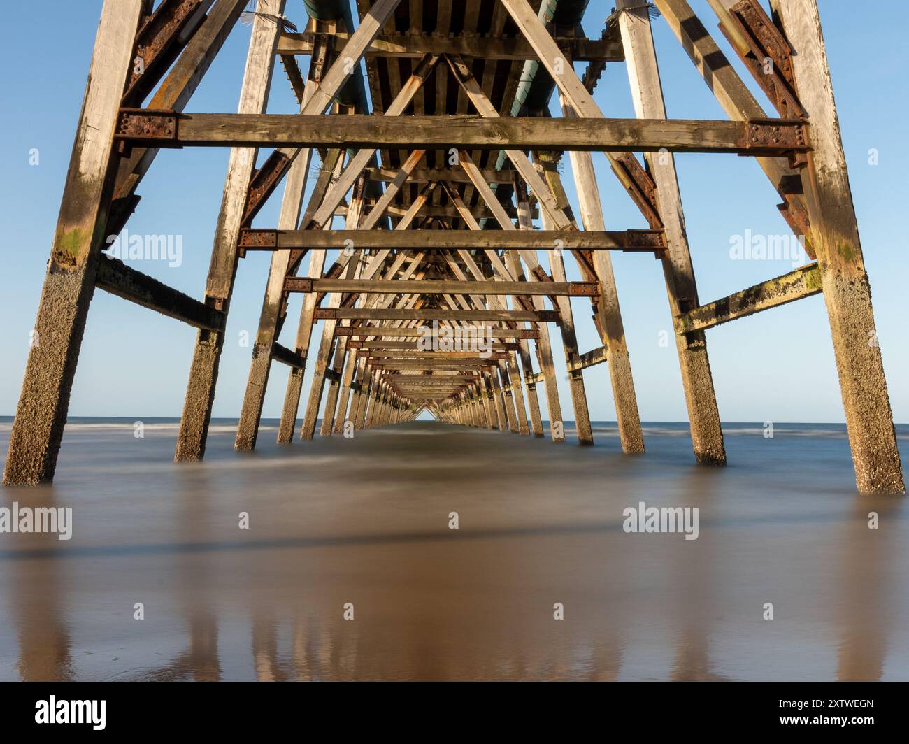 Wooden pier structure with its numerous pillars disappearing into the ...