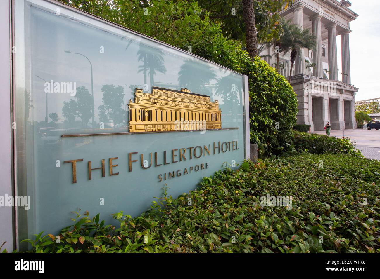 Side view glass sign of The Fullerton Hotel in a green landscaping ...