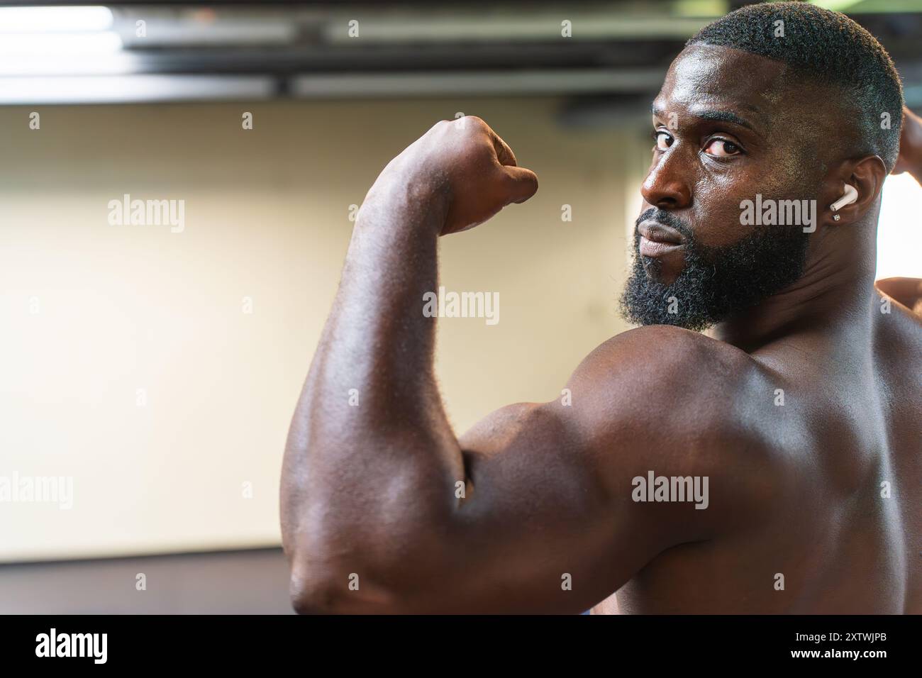 Black fitness trainer showing off his muscled arm Stock Photo - Alamy