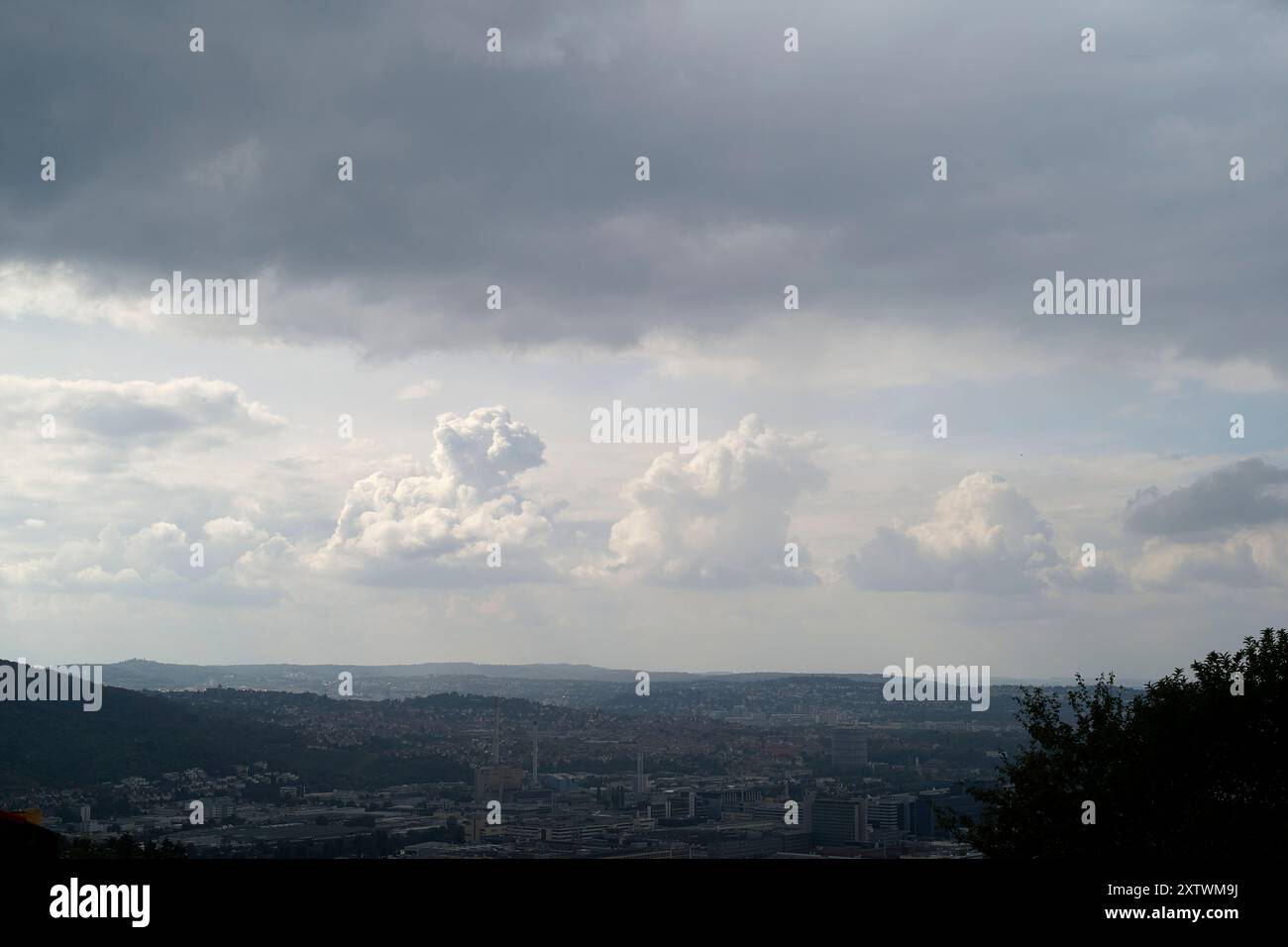 Overcast sky above a sprawling cityscape with visible cumulus clouds ...