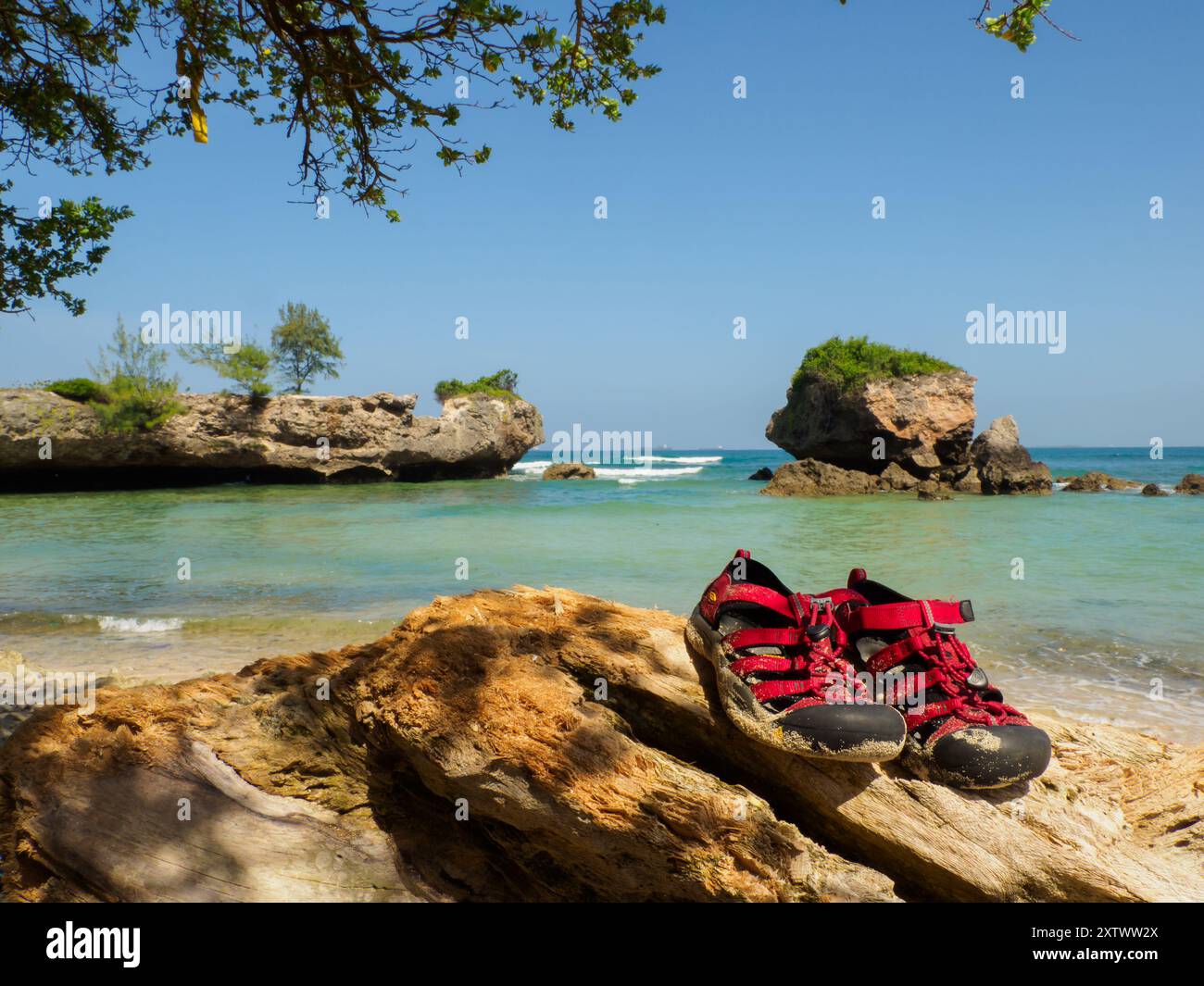Red shoes on the hidden sandy beach by the waters of the Indian Ocean ...