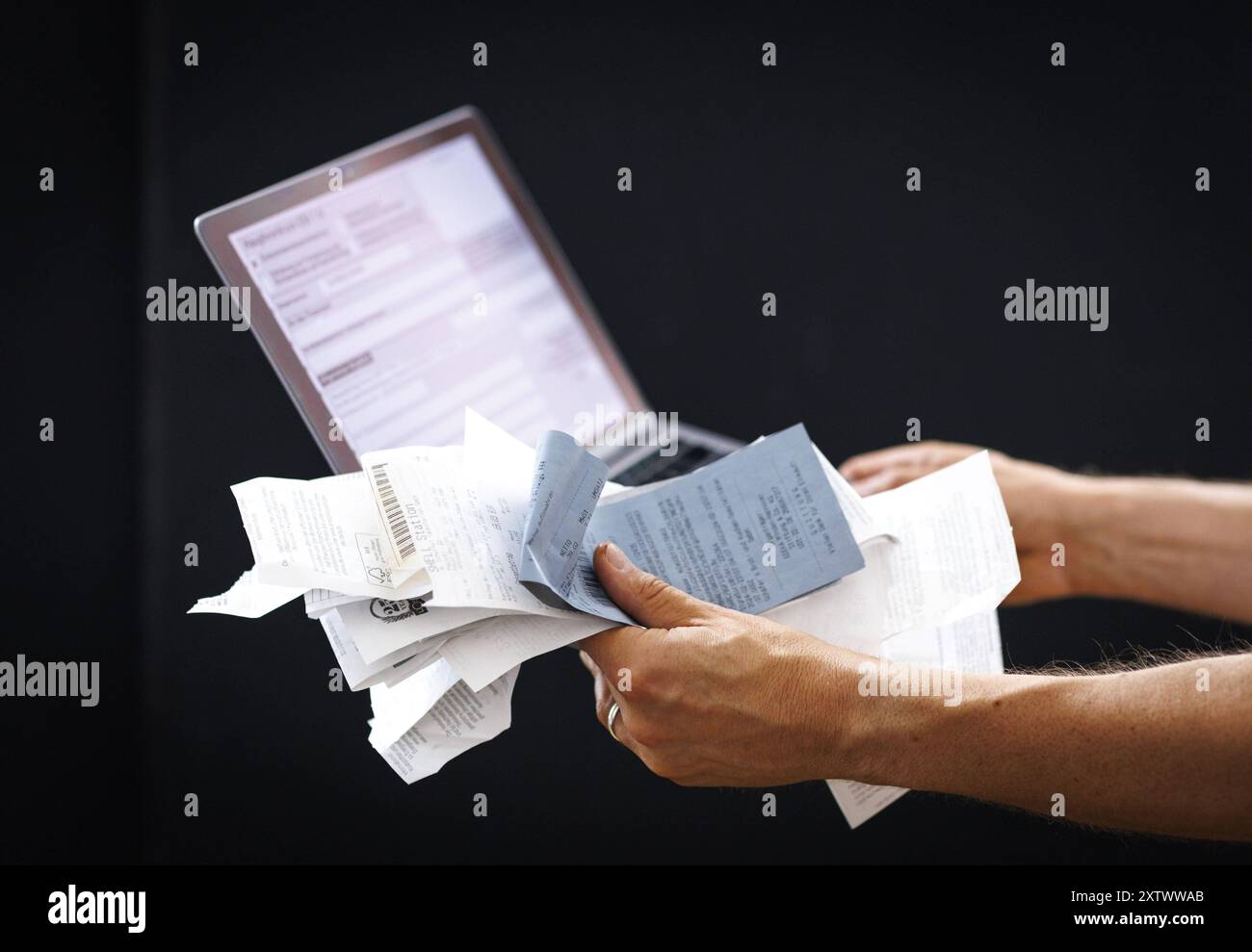 Thema Steuern. Eine Person haelt Belege und einen Laptop in Berlin, 09. ...