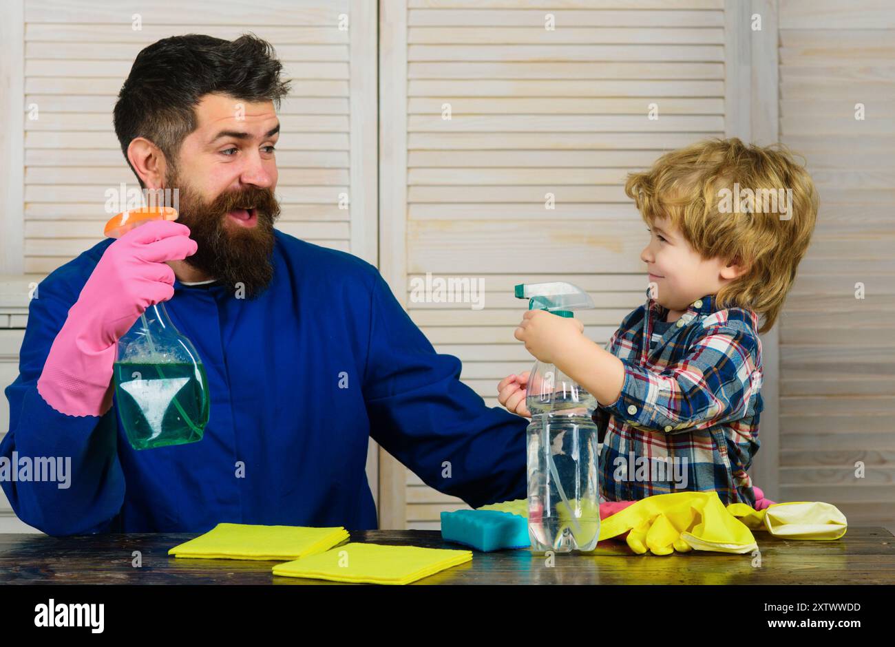 Father and son with cleaning supplies. Parents and child with rubber ...