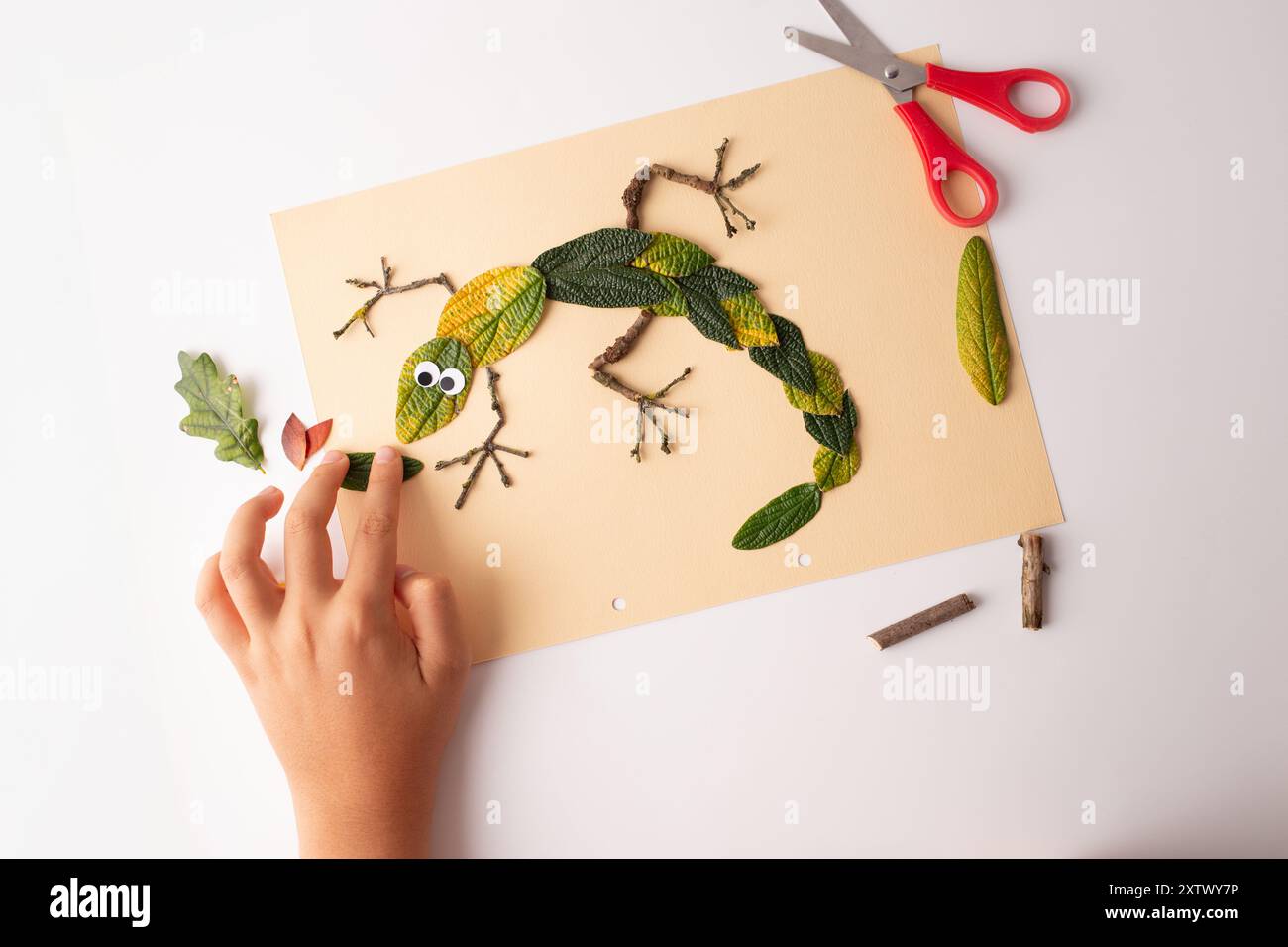 Lizard creatively depicted with natural materials on beige paper ...