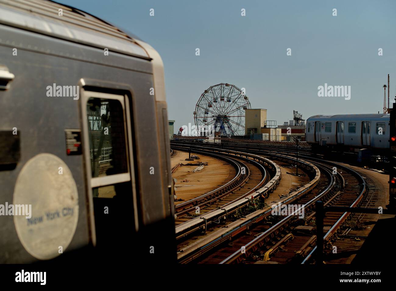 A New York City subway train with a view of a ferris wheel in the ...