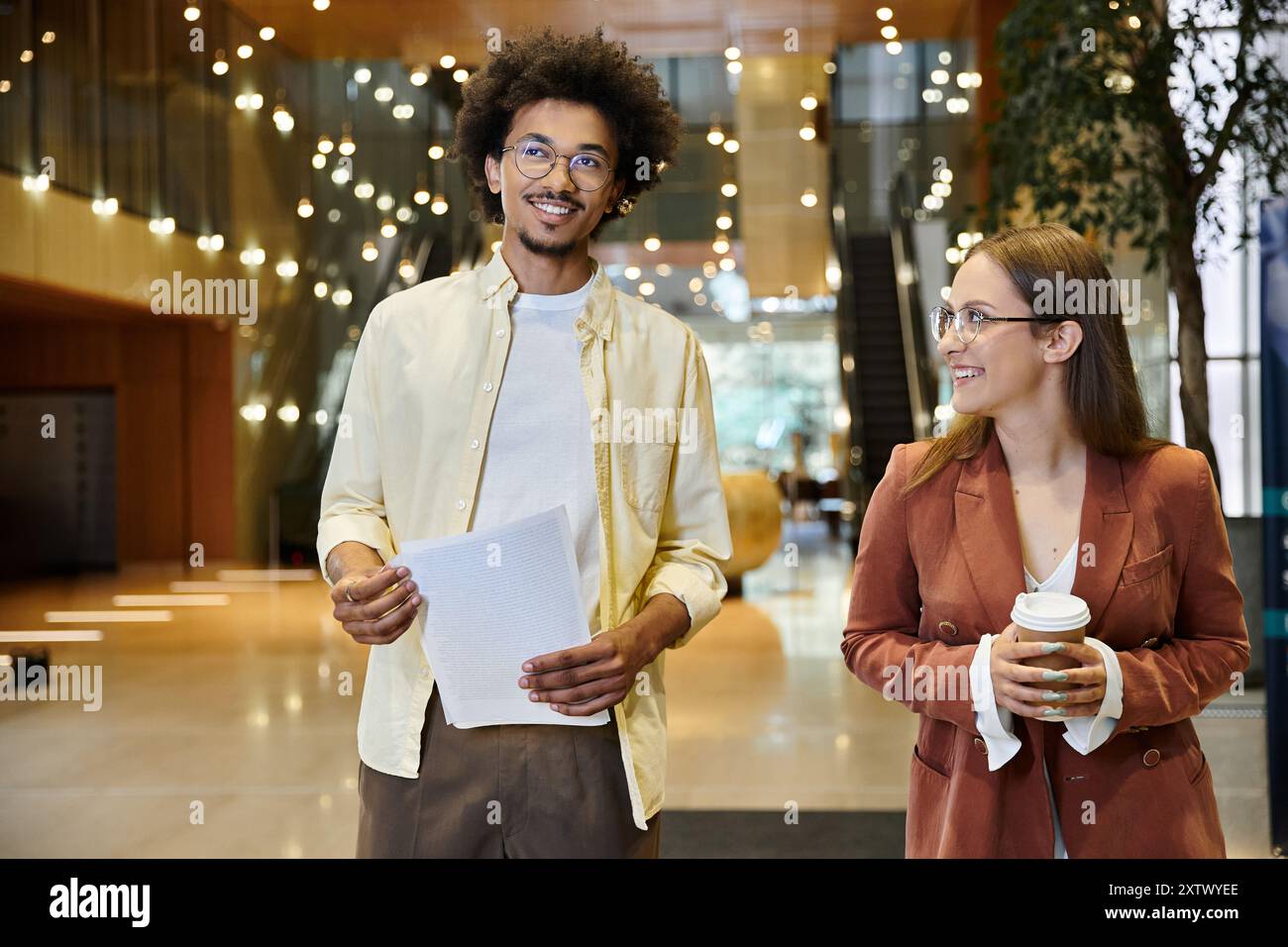 Two colleagues,chat and smile in the lobby of an office building Stock ...