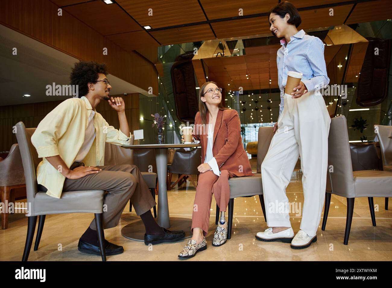 Multicultural colleagues enjoy a friendly conversation in a modern ...