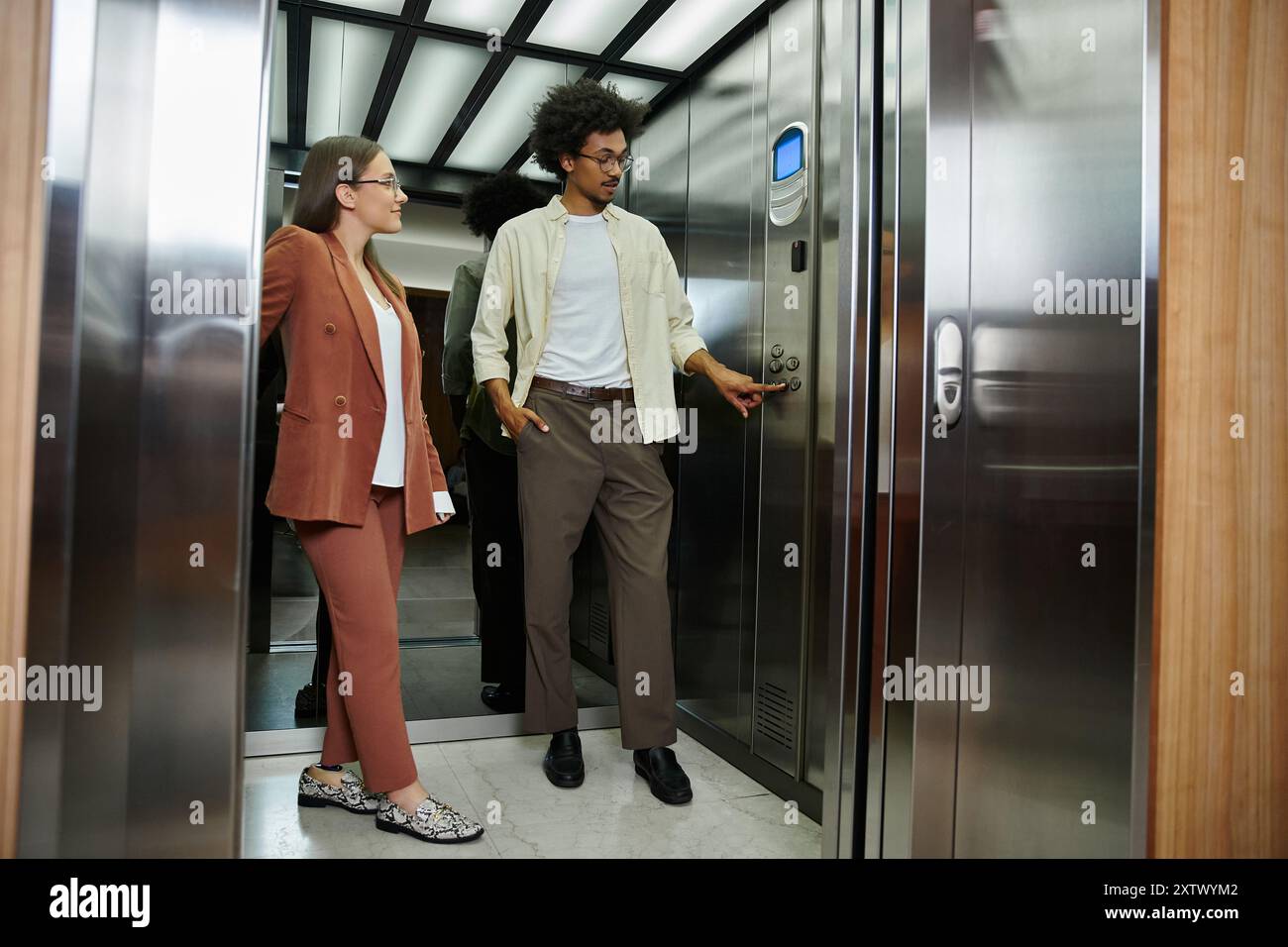 Two colleagues, one with a prosthetic leg, chat in an elevator, waiting ...