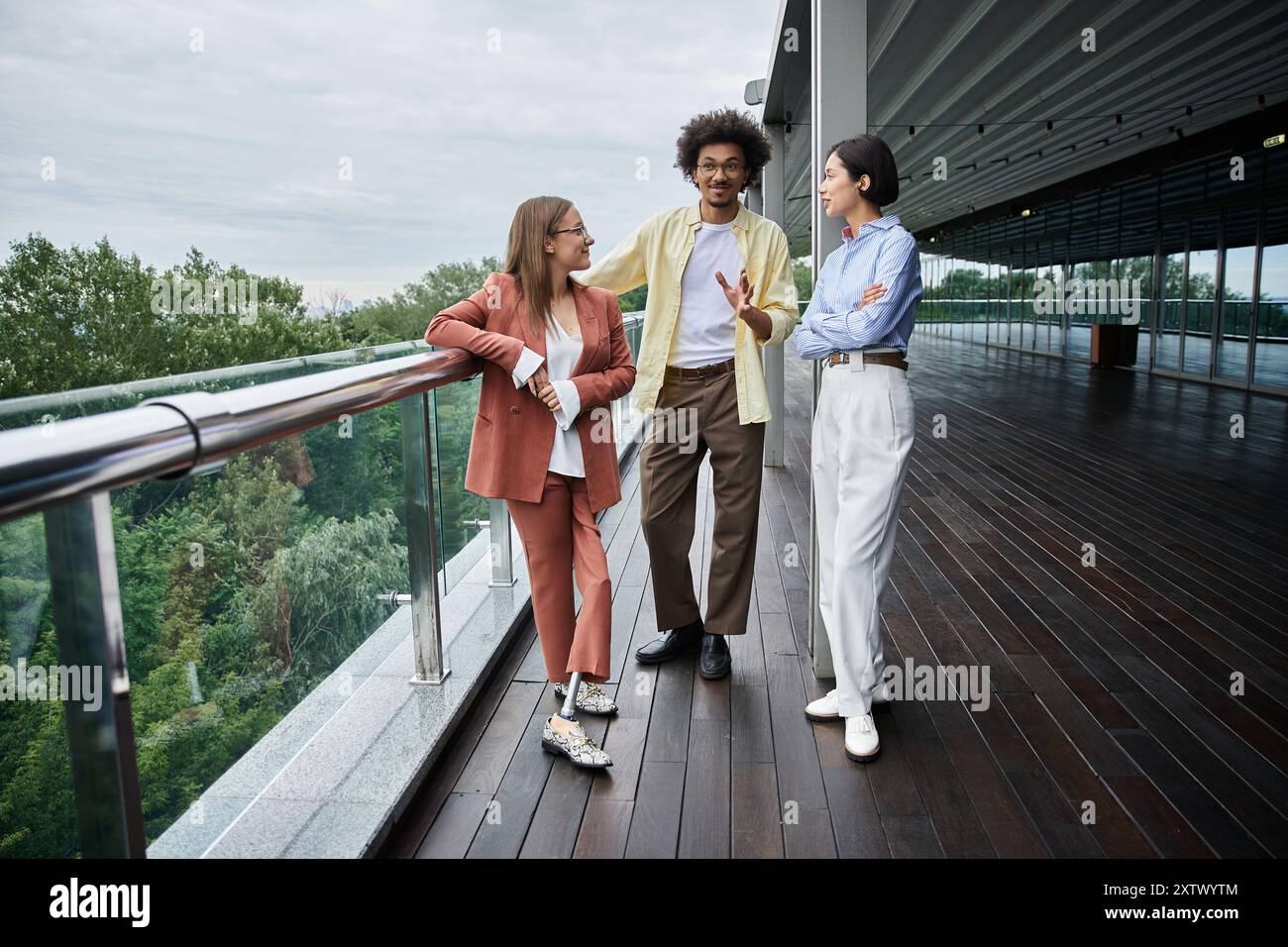 Three colleagues, including a woman with a prosthetic leg, chat and ...