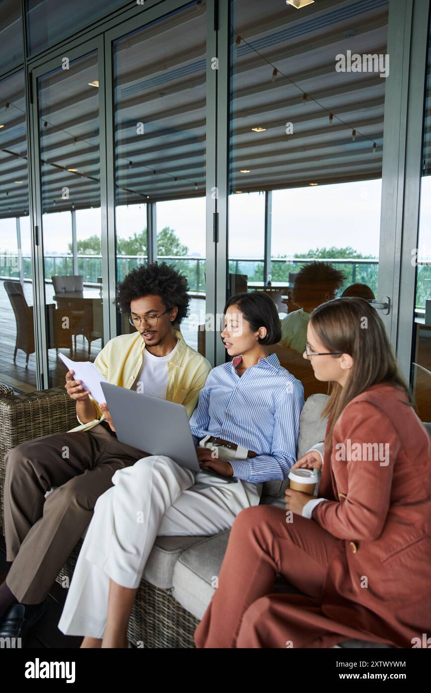 Colleagues have a relaxed chat on a rooftop terrace, emphasizing ...