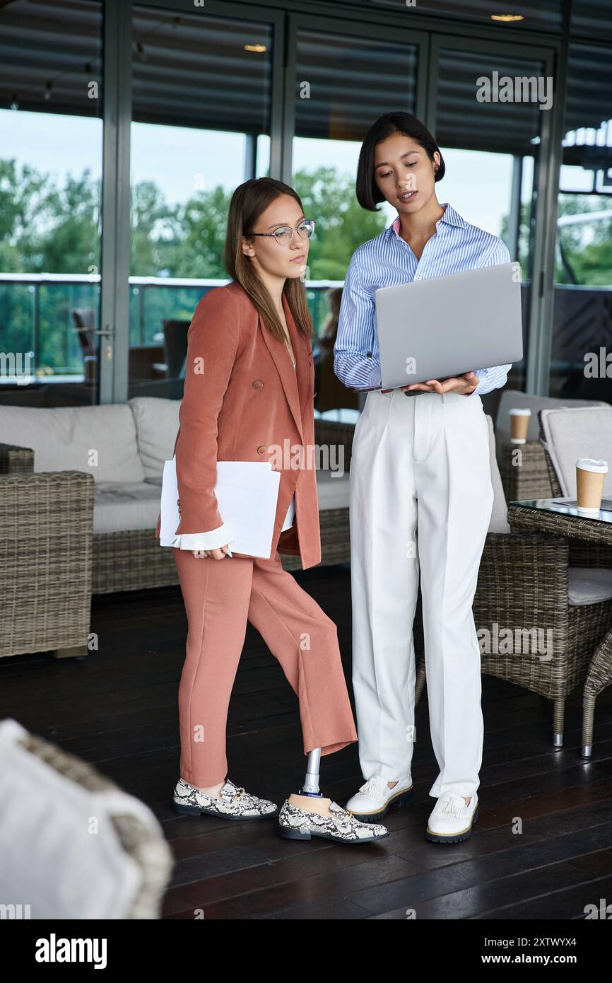 Two colleagues, one with a prosthetic leg, chat on a rooftop terrace ...