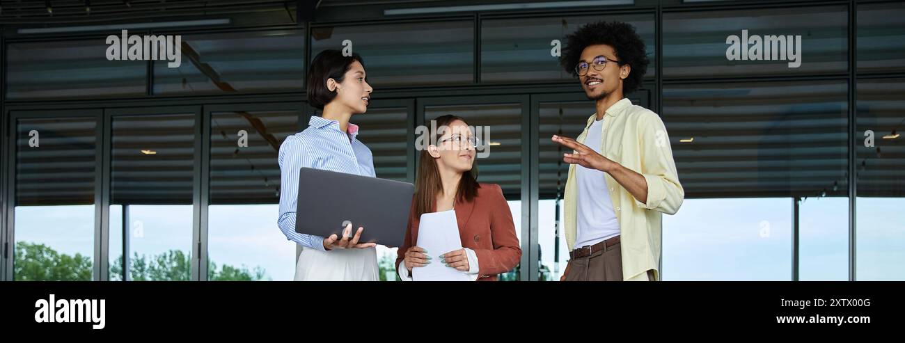 Three colleagues chat and collaborate on a rooftop terrace Stock Photo ...