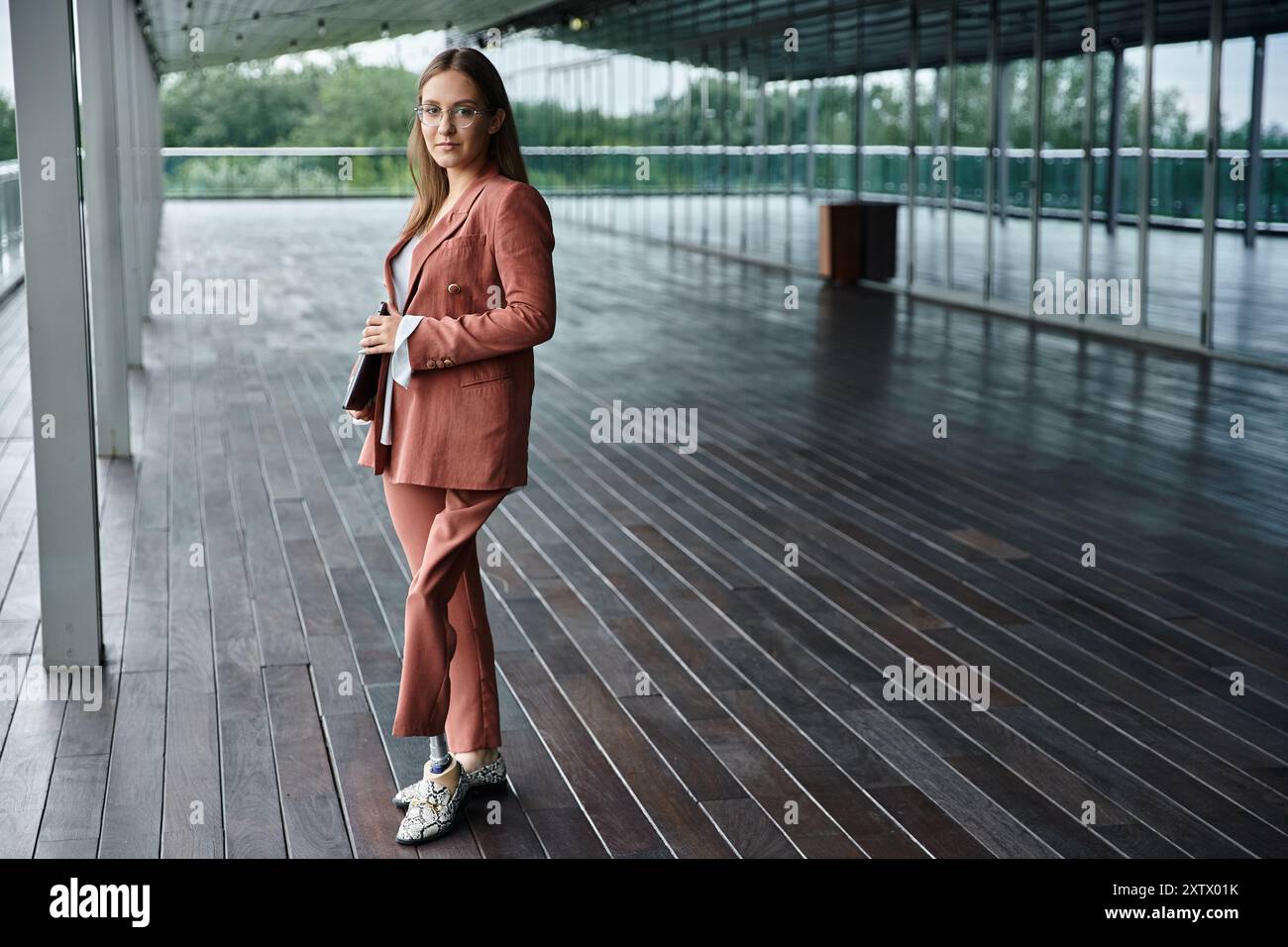A woman in a pink suit, with prosthetic leg standing confidently on a ...