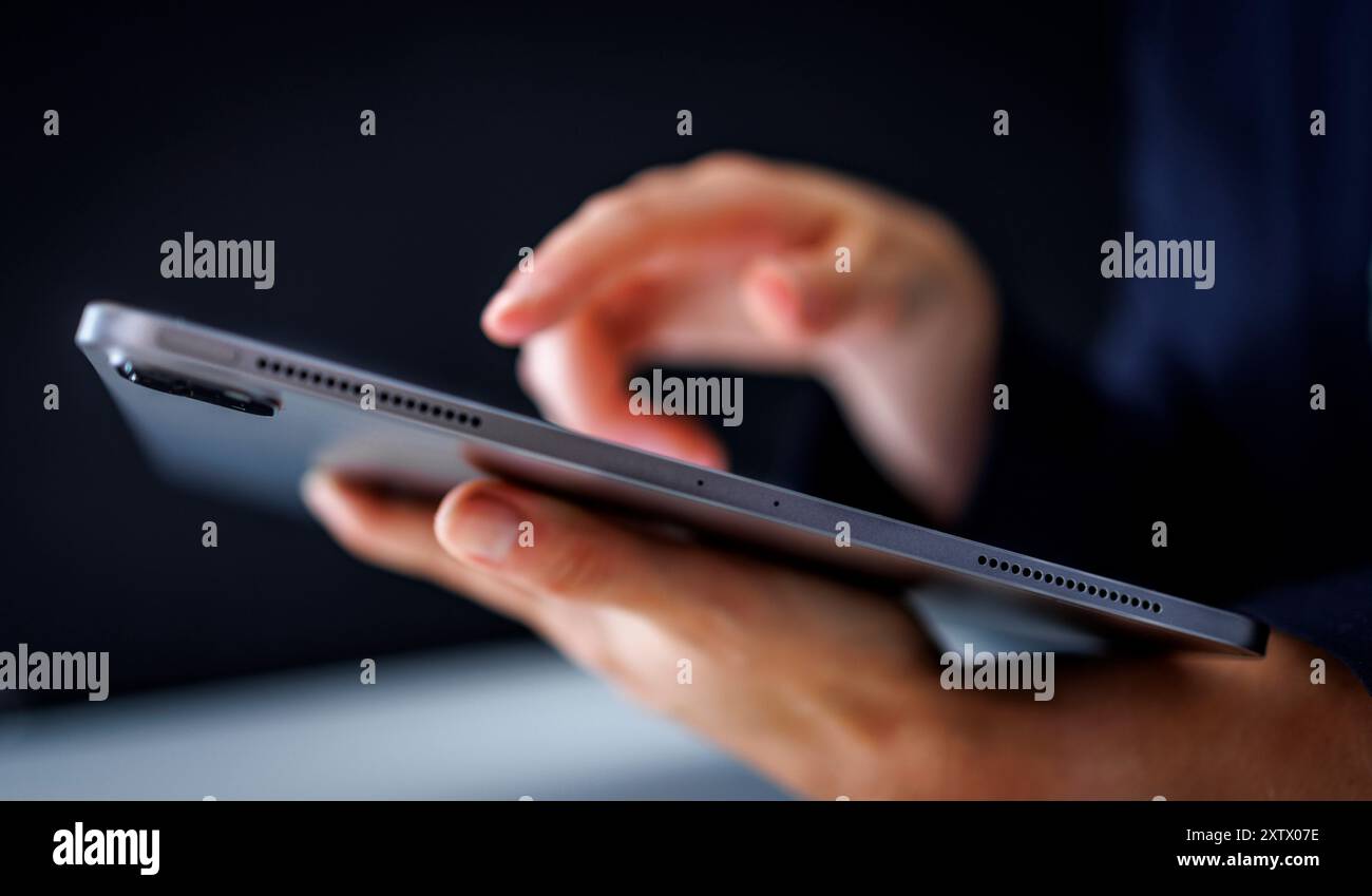 Berlin, Deutschland. 09th Aug, 2024. Hands typing on a tablet in Berlin ...