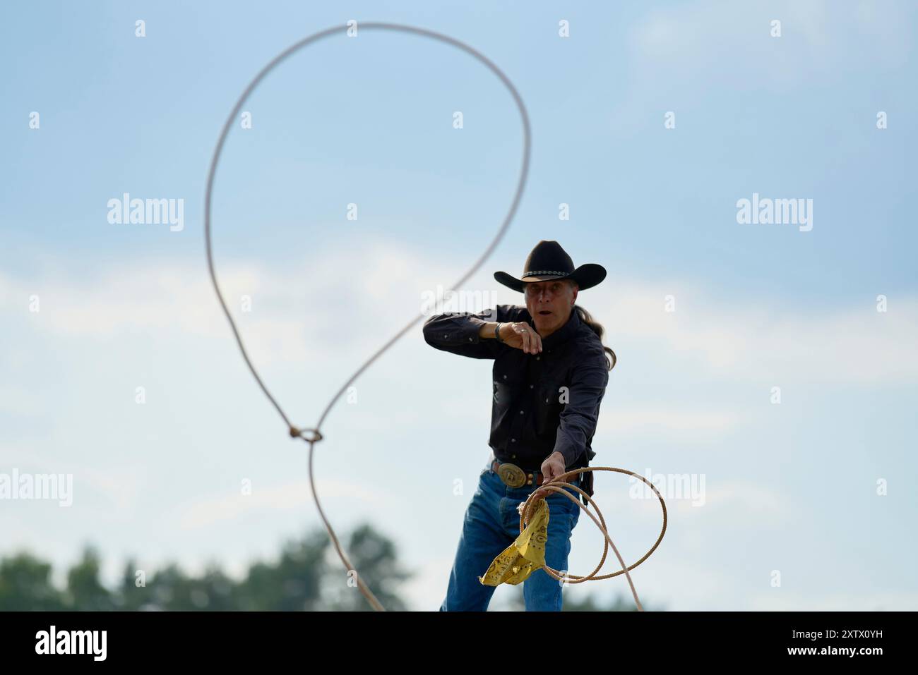 Cowboy demonstrating lasso skills under a blue sky Stock Photo - Alamy