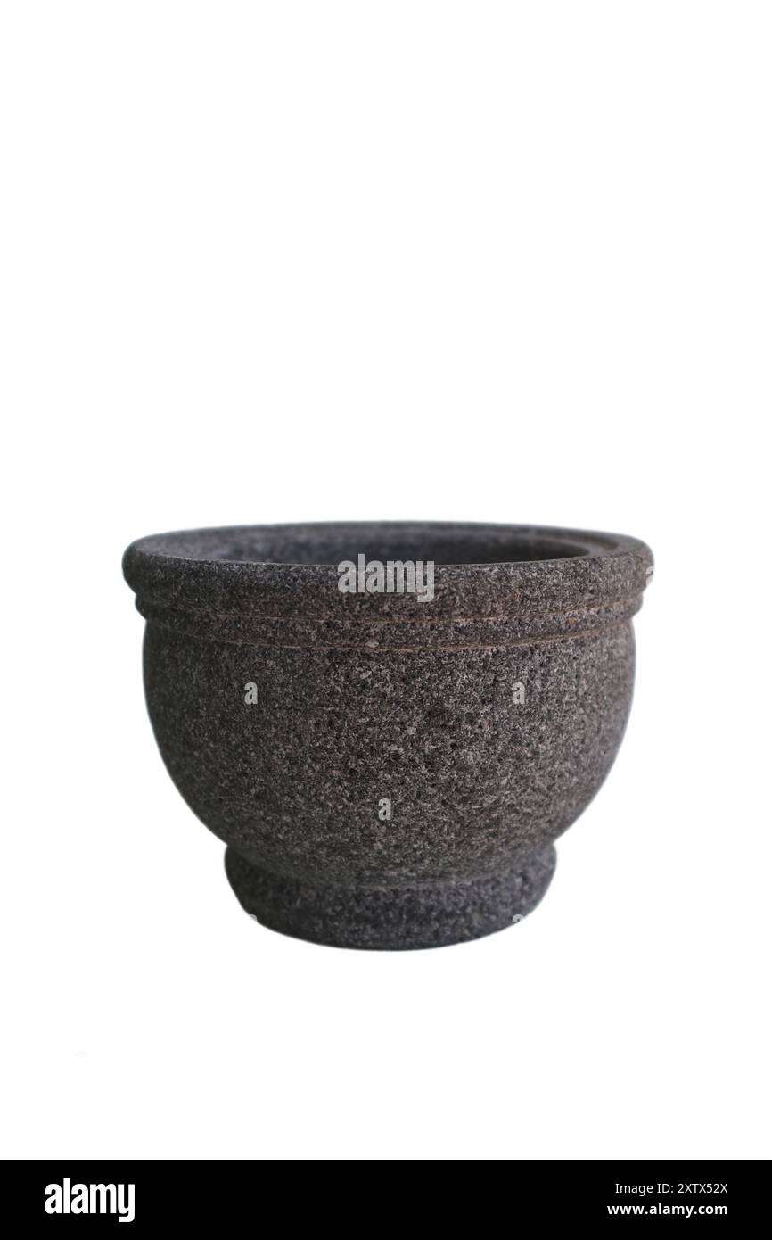 A large mortar and pestle sits on a white background. The mortar is ...