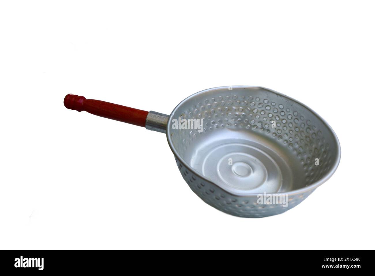A silver pan with a wooden handle sits on a white background. The pan ...