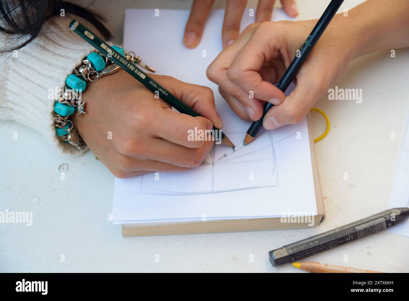 Unrecognizable Multi ethnic female hands drawing lines on a blank sheet ...