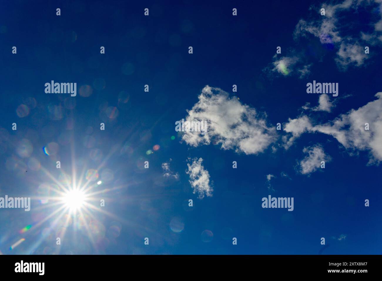 Blue sky with clouds and sun reflection Stock Photo - Alamy