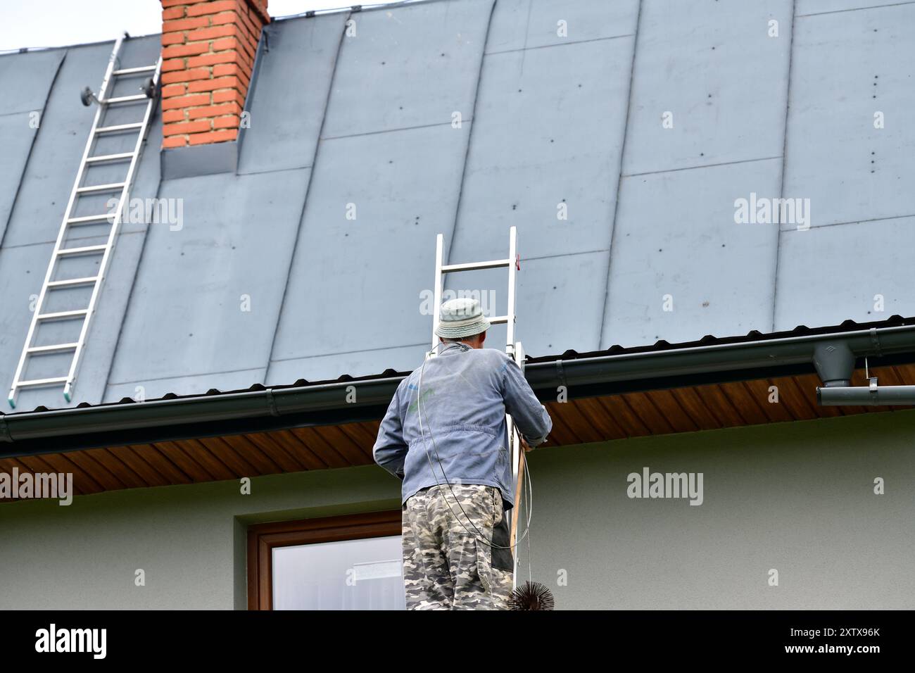 Traditional manual method of cleaning the chimney on the roof Stock ...
