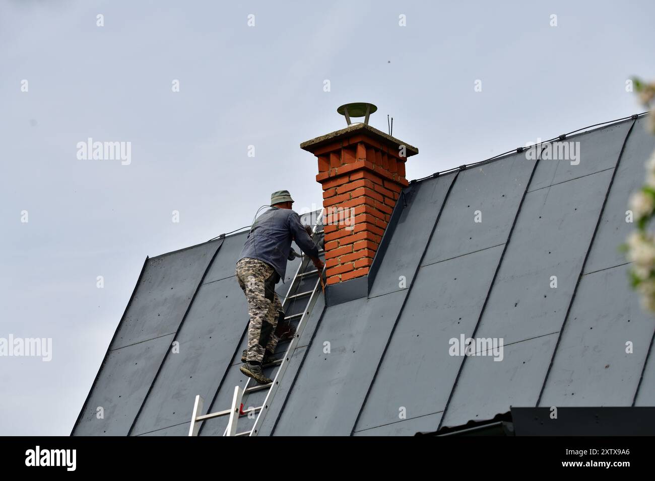 Traditional manual method of cleaning the chimney on the roof Stock ...