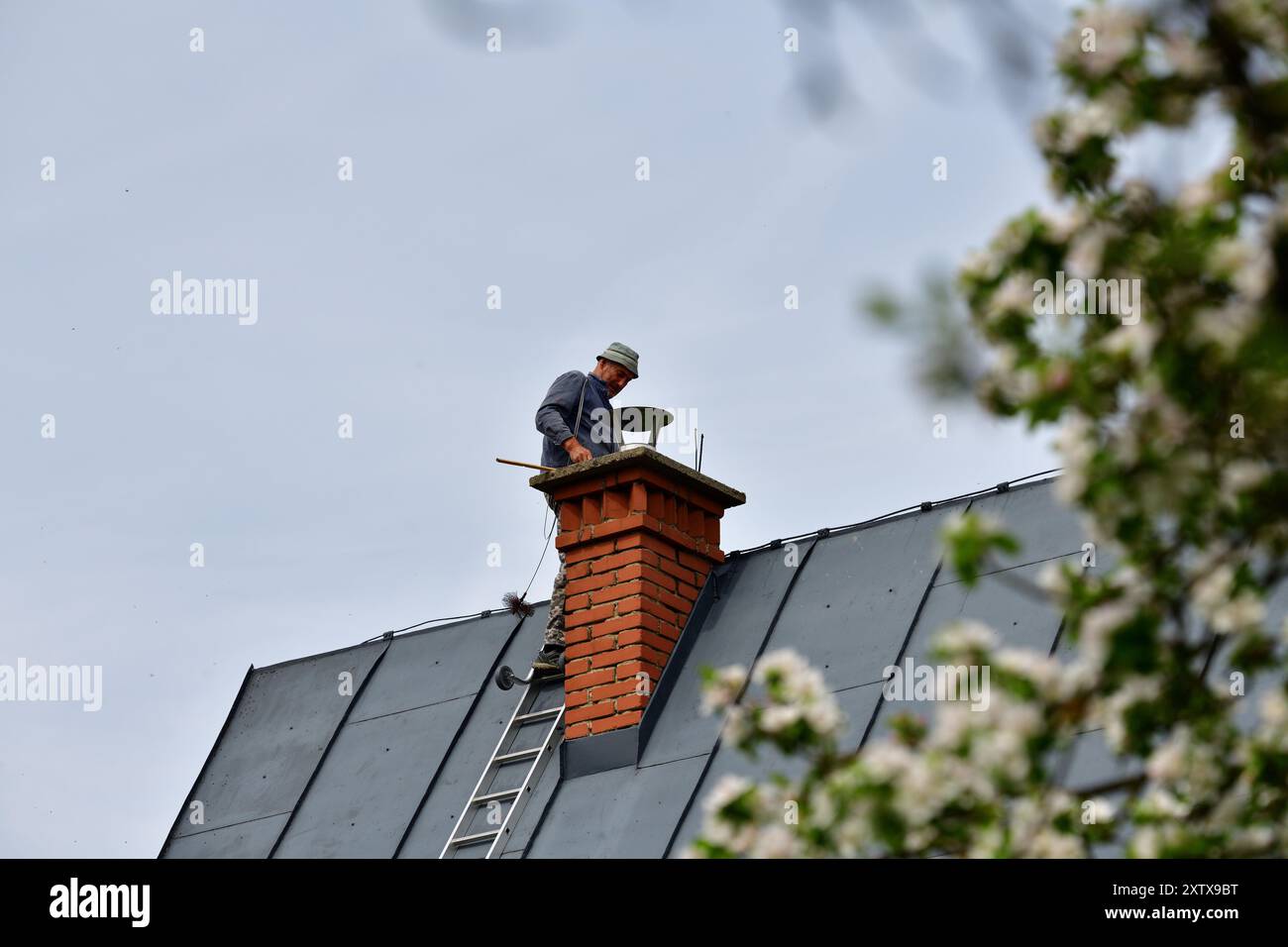 Traditional manual method of cleaning the chimney on the roof Stock ...