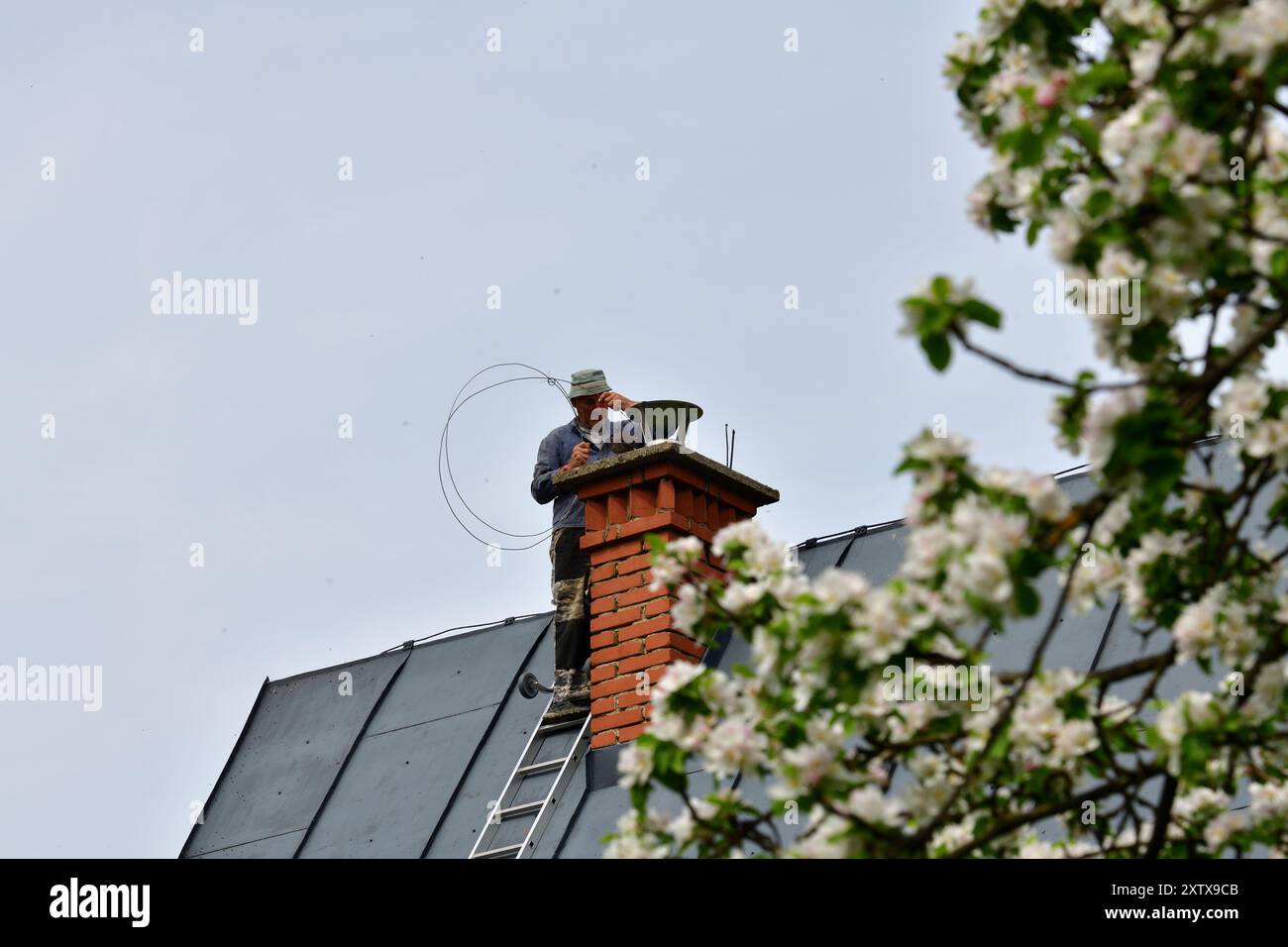 Traditional manual method of cleaning the chimney on the roof Stock ...