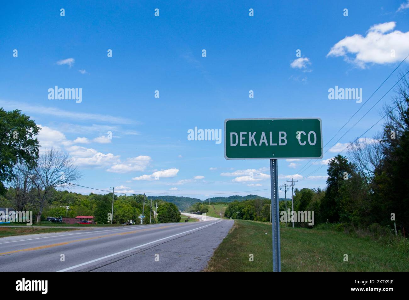 County line road sign on a rural highway with hills in the distance ...