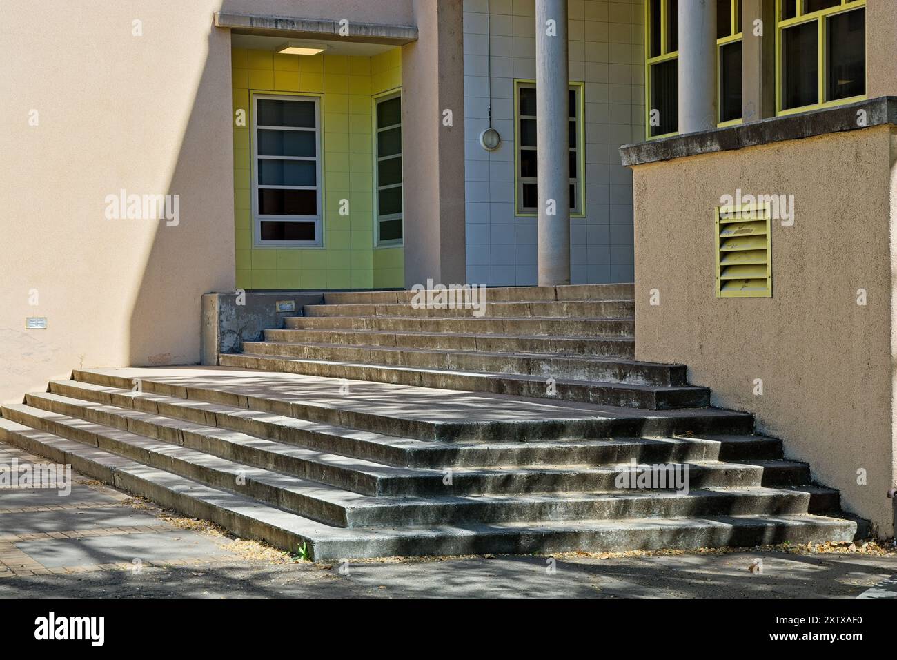 Dappled sunlight lit wide concrete stairs leading to entrance of campus ...