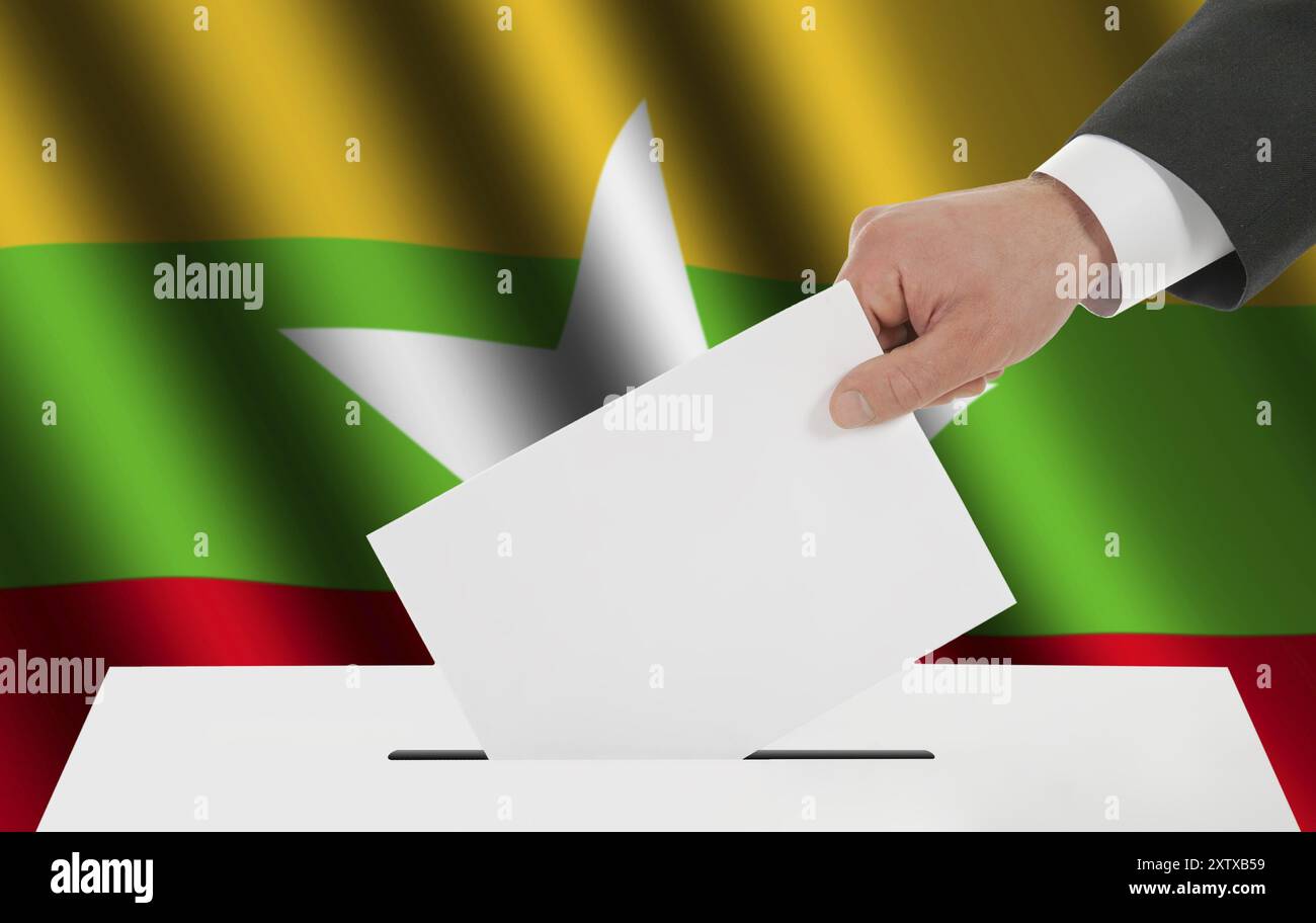 The Myanmar flag and the hand with the bulletin about the ballot box ...