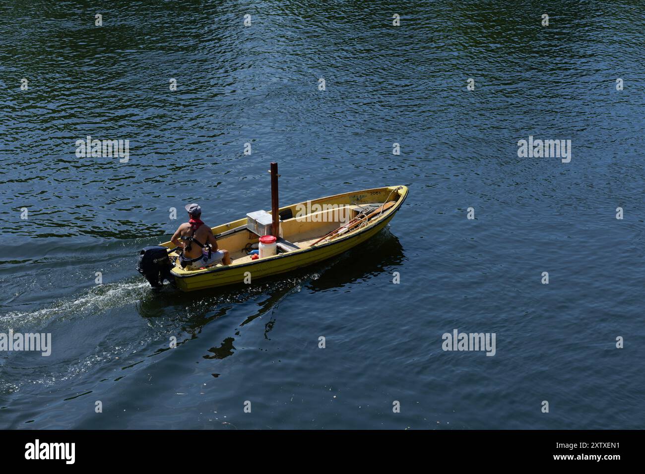 Man in rowing boat with oars and outboard motor, River Thames, Richmond ...