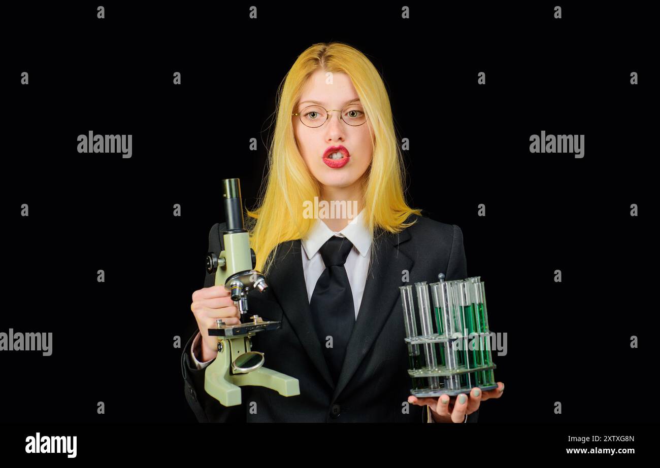 Chemistry lesson. Female student with test tubes and microscope in ...