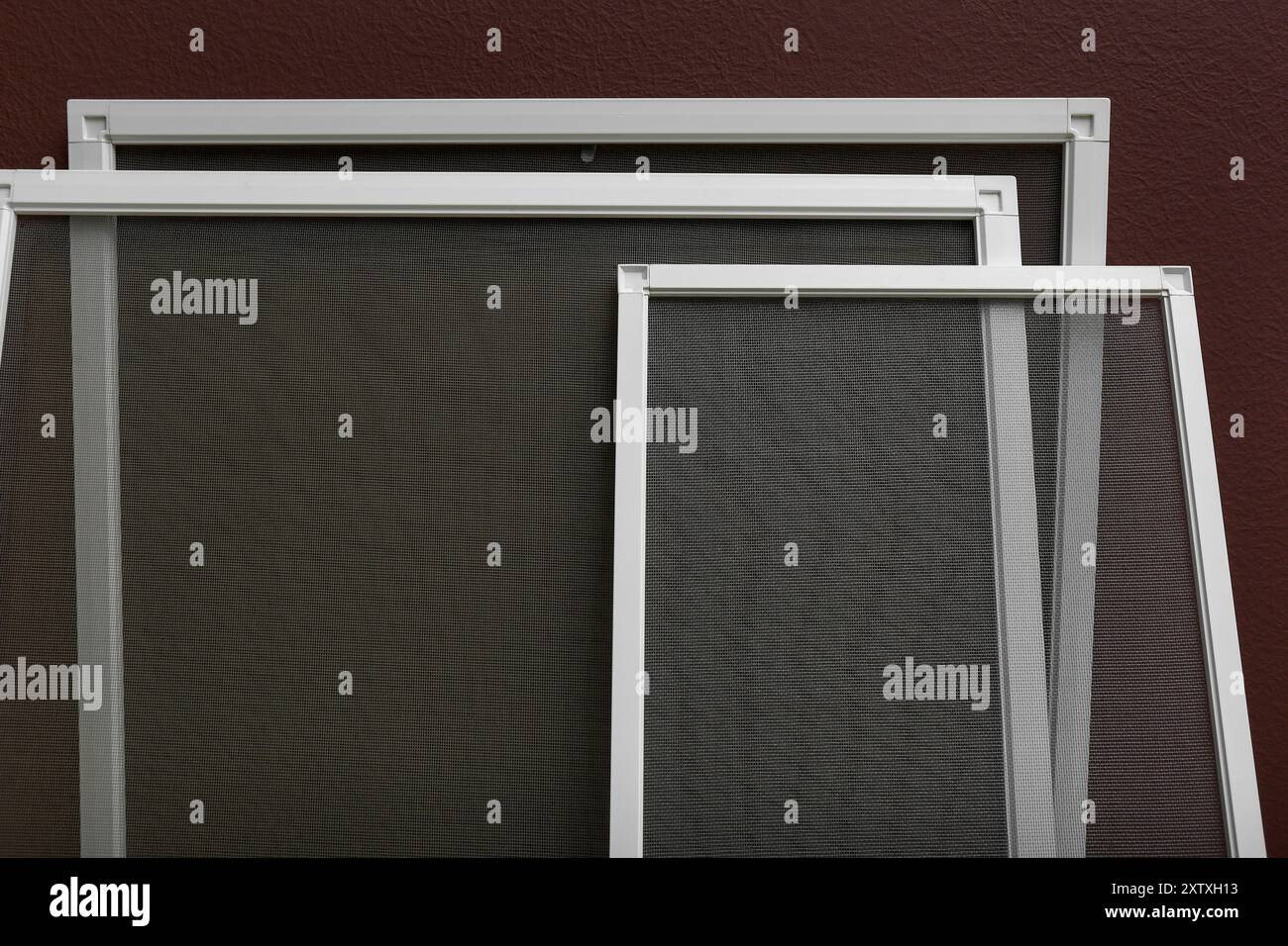 Set of window screens near brown wall Stock Photo - Alamy
