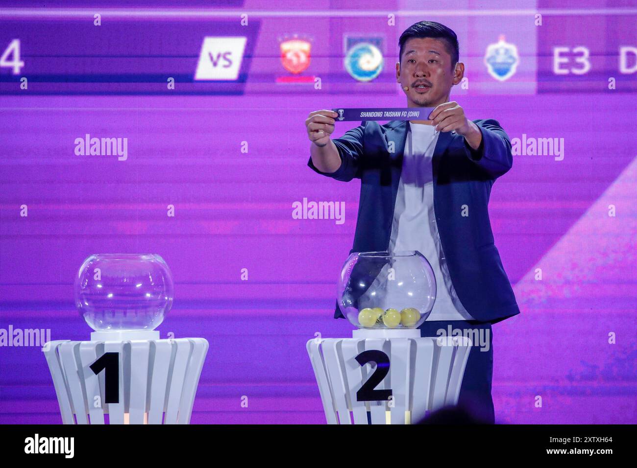 Japan's former football player Yuzo Kurihara displays the draw for ...