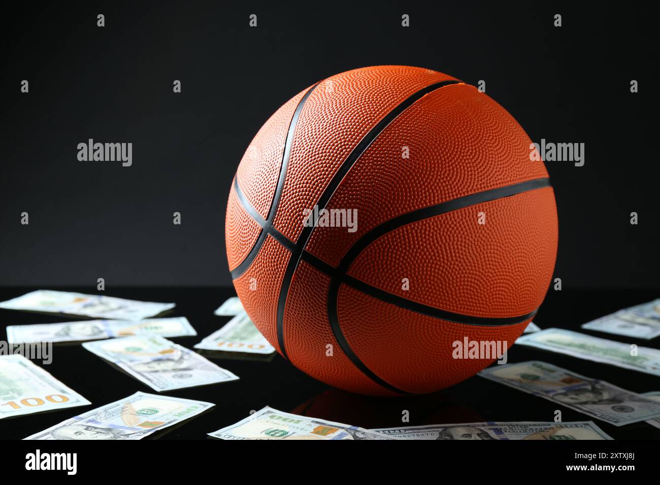 Basketball ball and dollar banknotes on black background Stock Photo ...