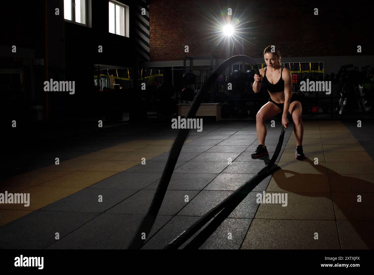 Powerful attractive muscular woman battle rope workout at the gym ...