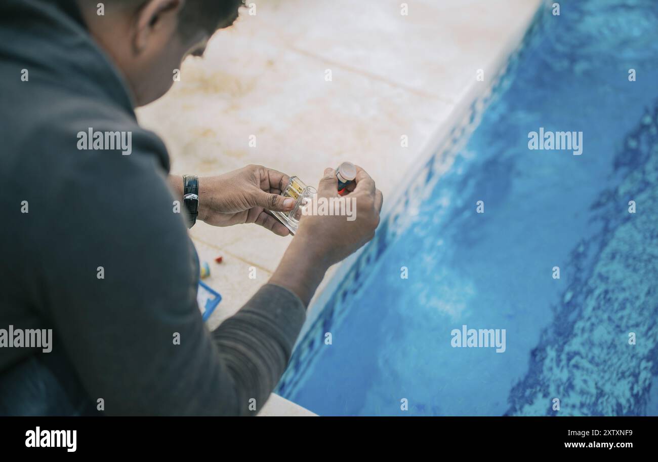 Tester kit to measure chlorine and ph in swimming pools. Person testing ...