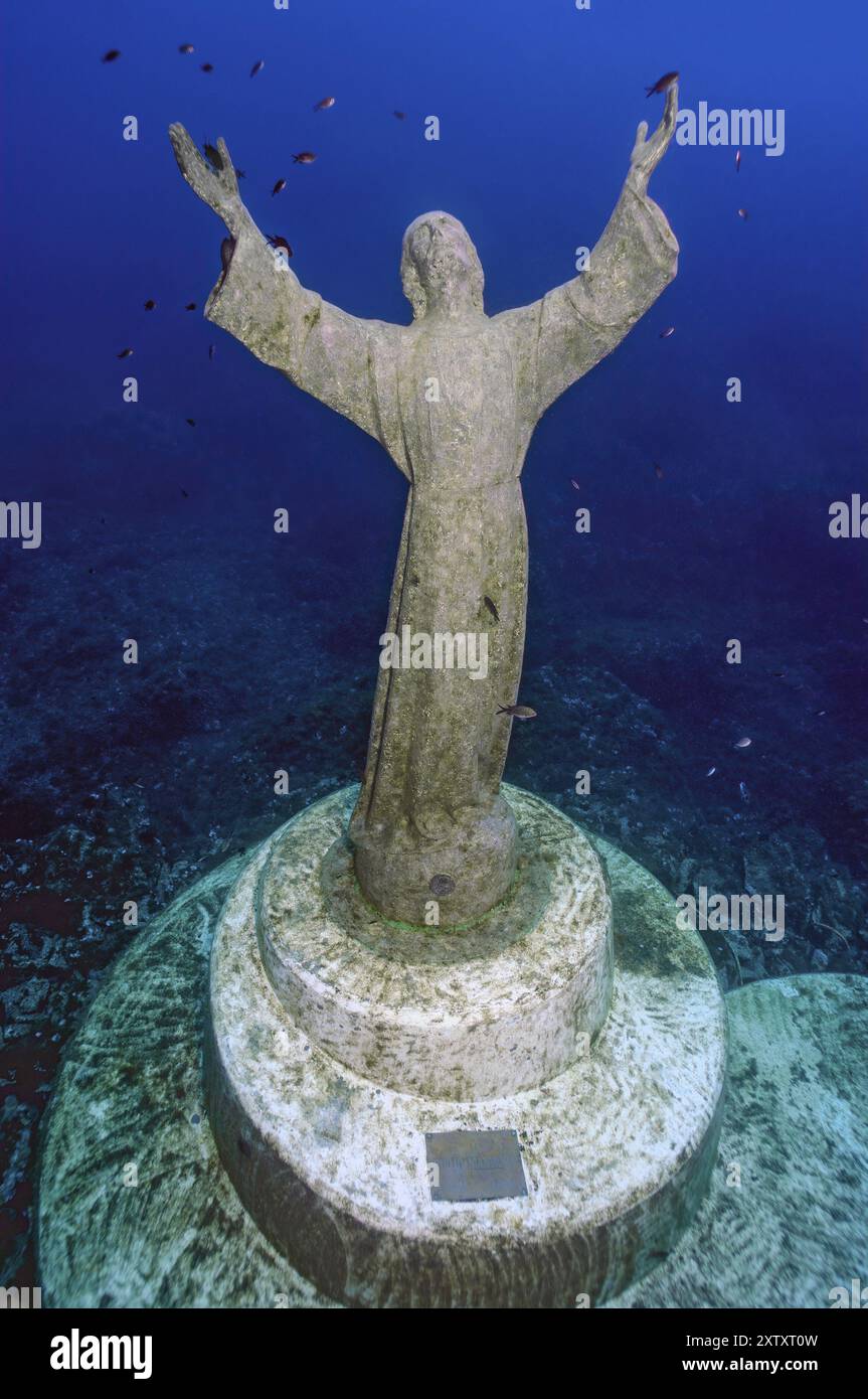 Statue of Jesus Christ on a pedestal under water, stretching out his ...