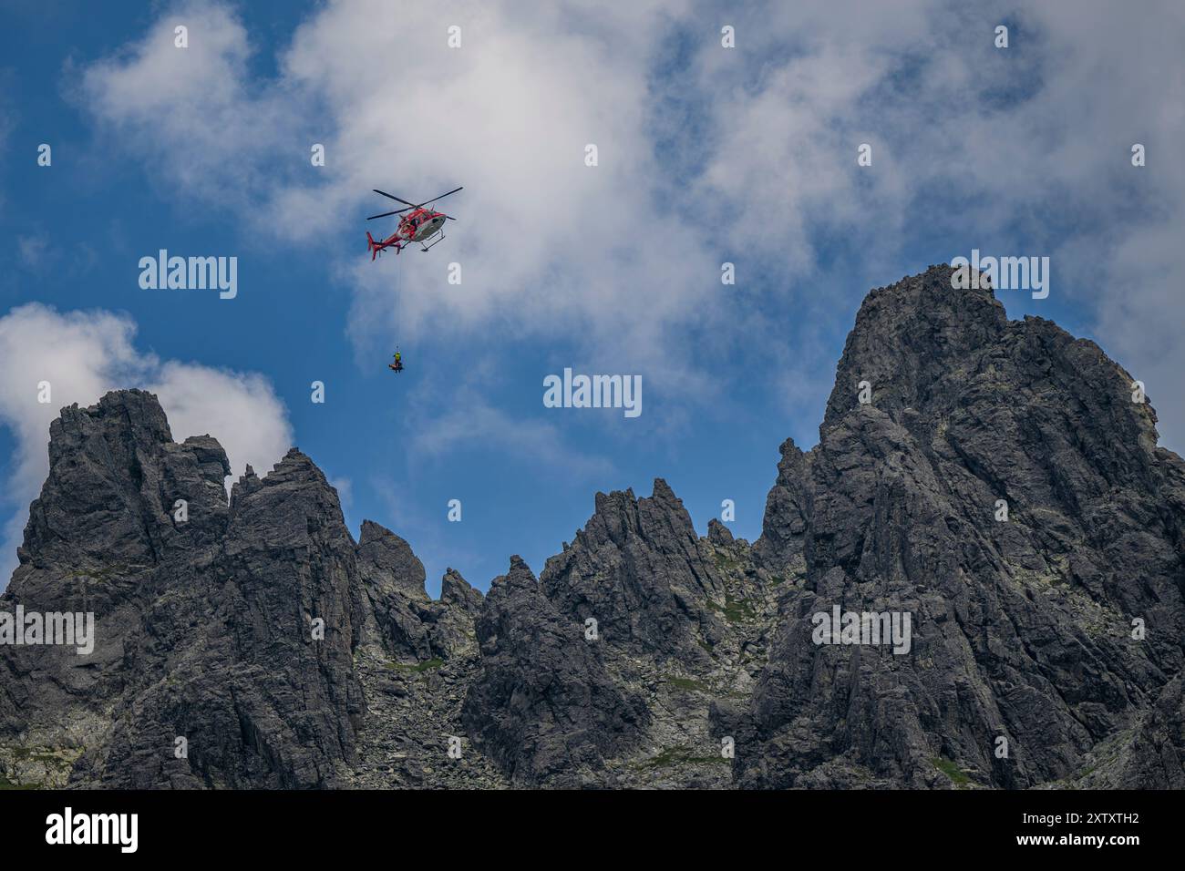 Mountain rescue operation. Evacuation of climbers using a helicopter ...