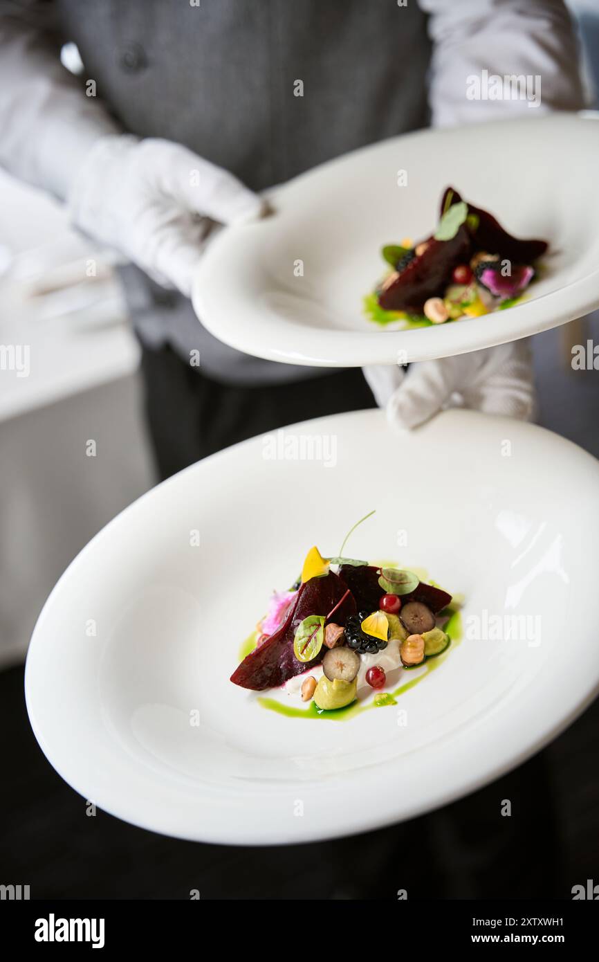 Male waiter carrying two plates of salads in a restaurant Stock Photo ...