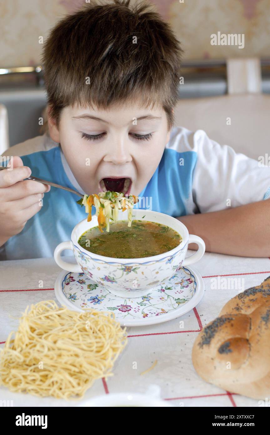 Boy eating homemade noodles Stock Photo - Alamy