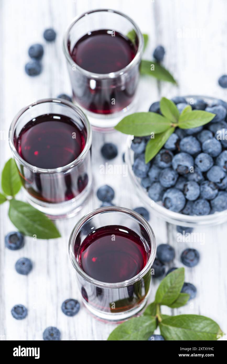 Blueberry Liqueur with some fresh fruits in a small glass Stock Photo ...