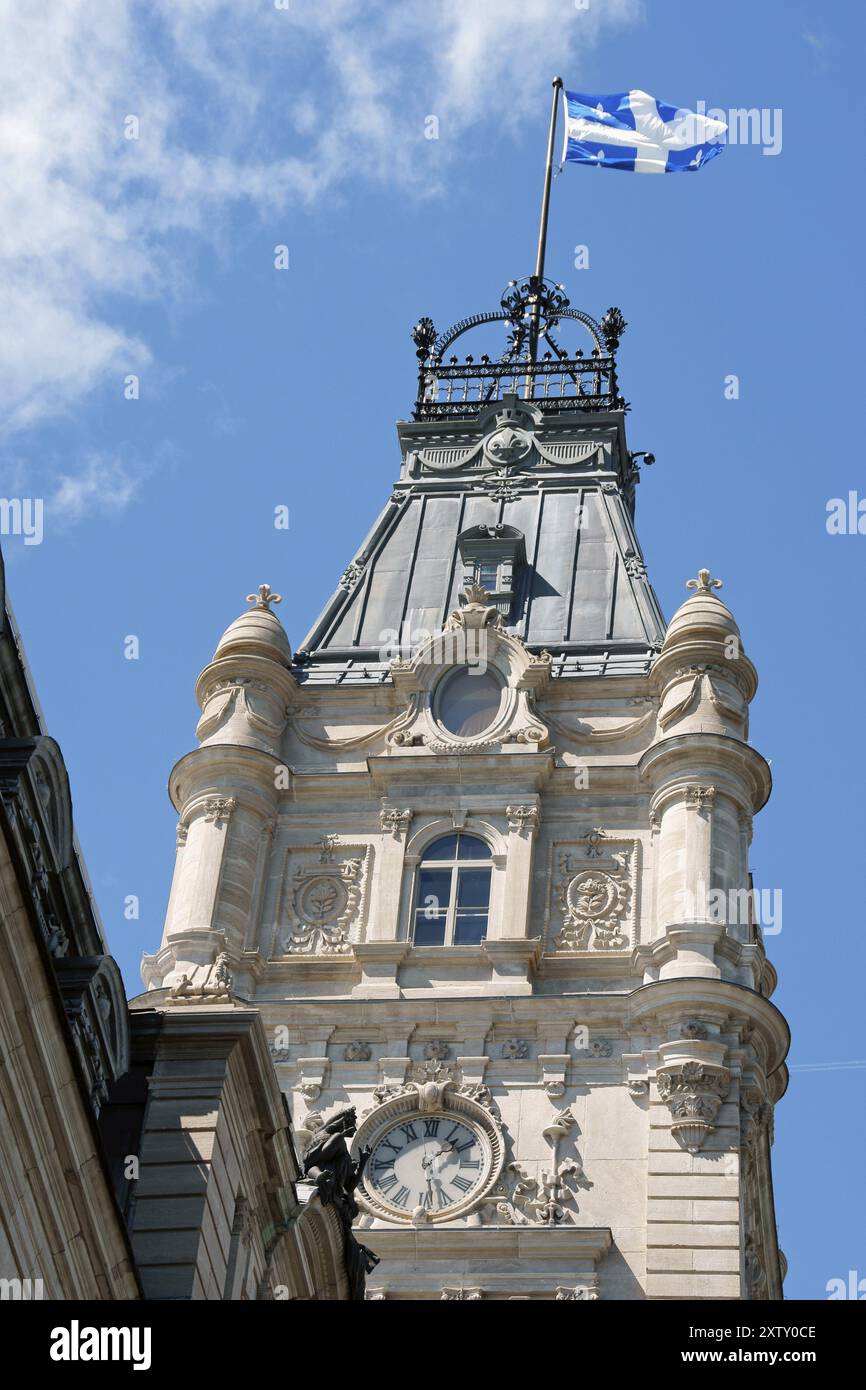 The clock tower of Parliament of Quebec building and Quebec flag. This ...