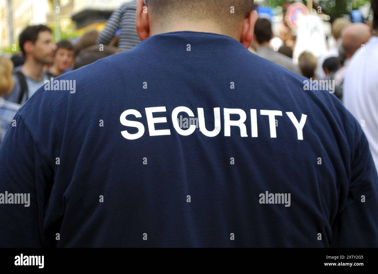 Security guard in front of crowd Stock Photo - Alamy