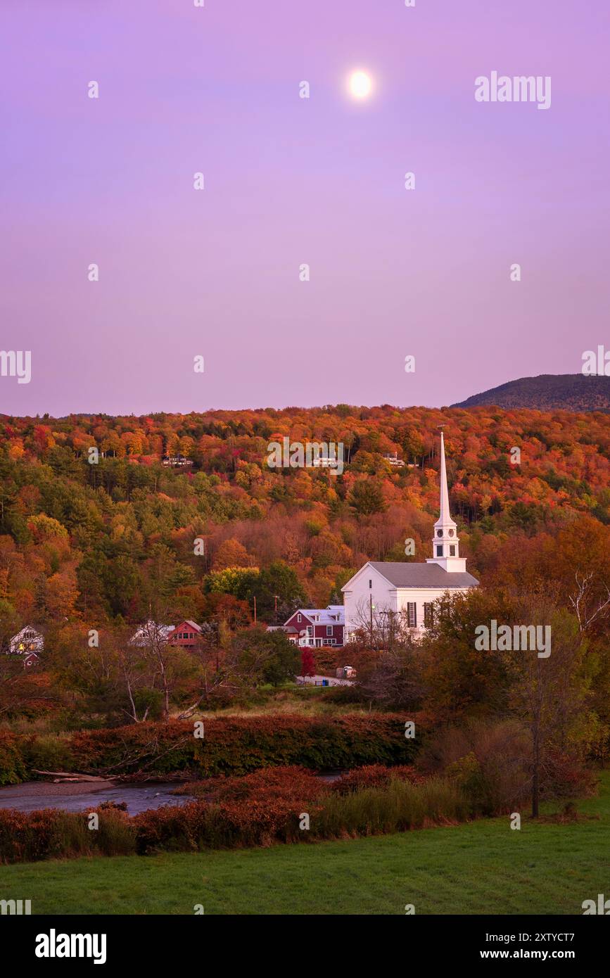 Tradityiona white church in a village surrounded by forested mountains ...