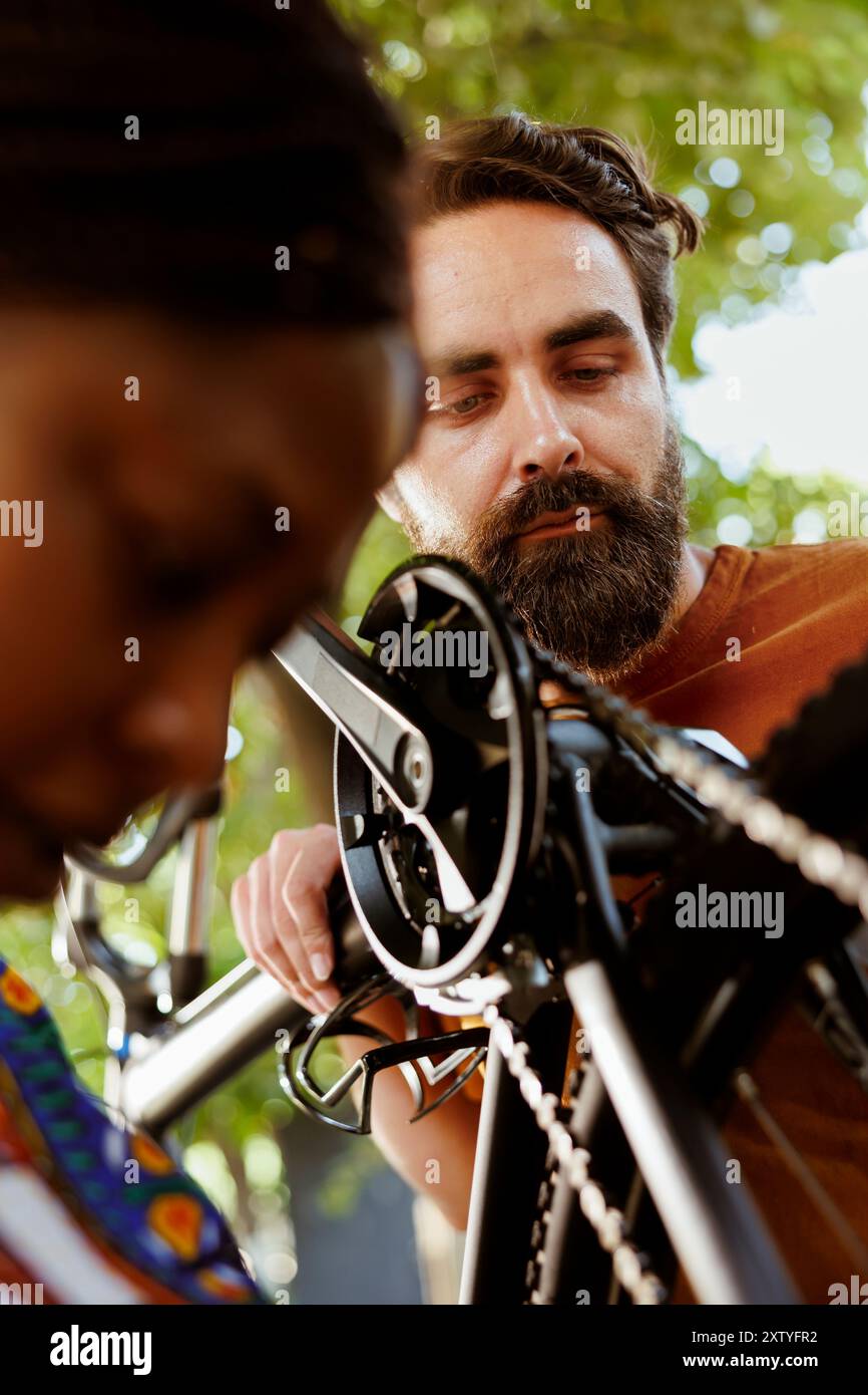 Detailed shot of fit and young caucasian male inspecting modern bicycle ...