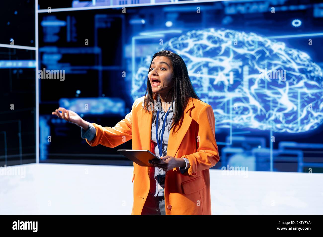 Woman using mic and tablet to do presentation at event bringing ...